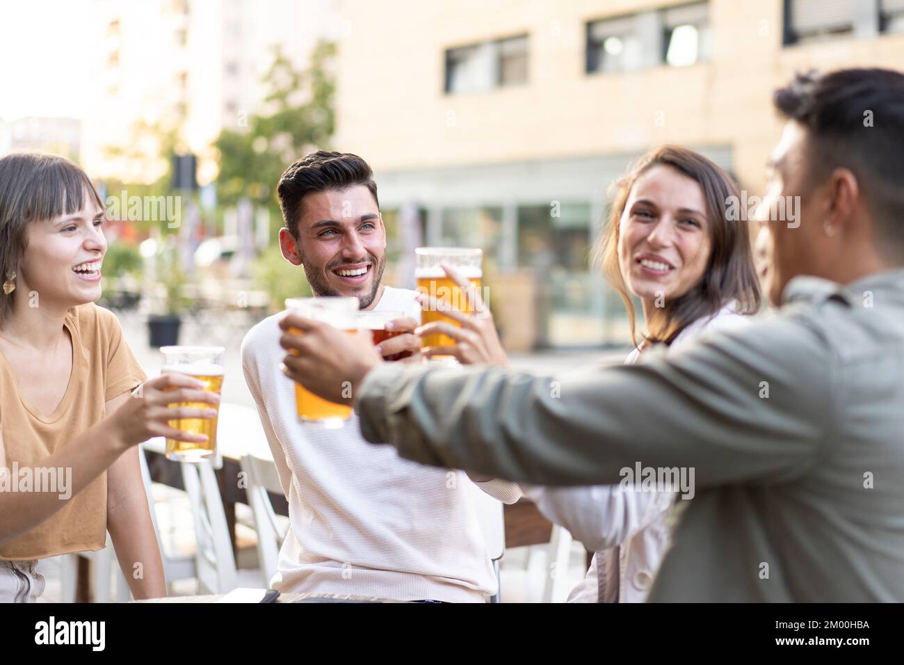 Multiracial friends drinking beer at brewery pub garden - Genuine ...