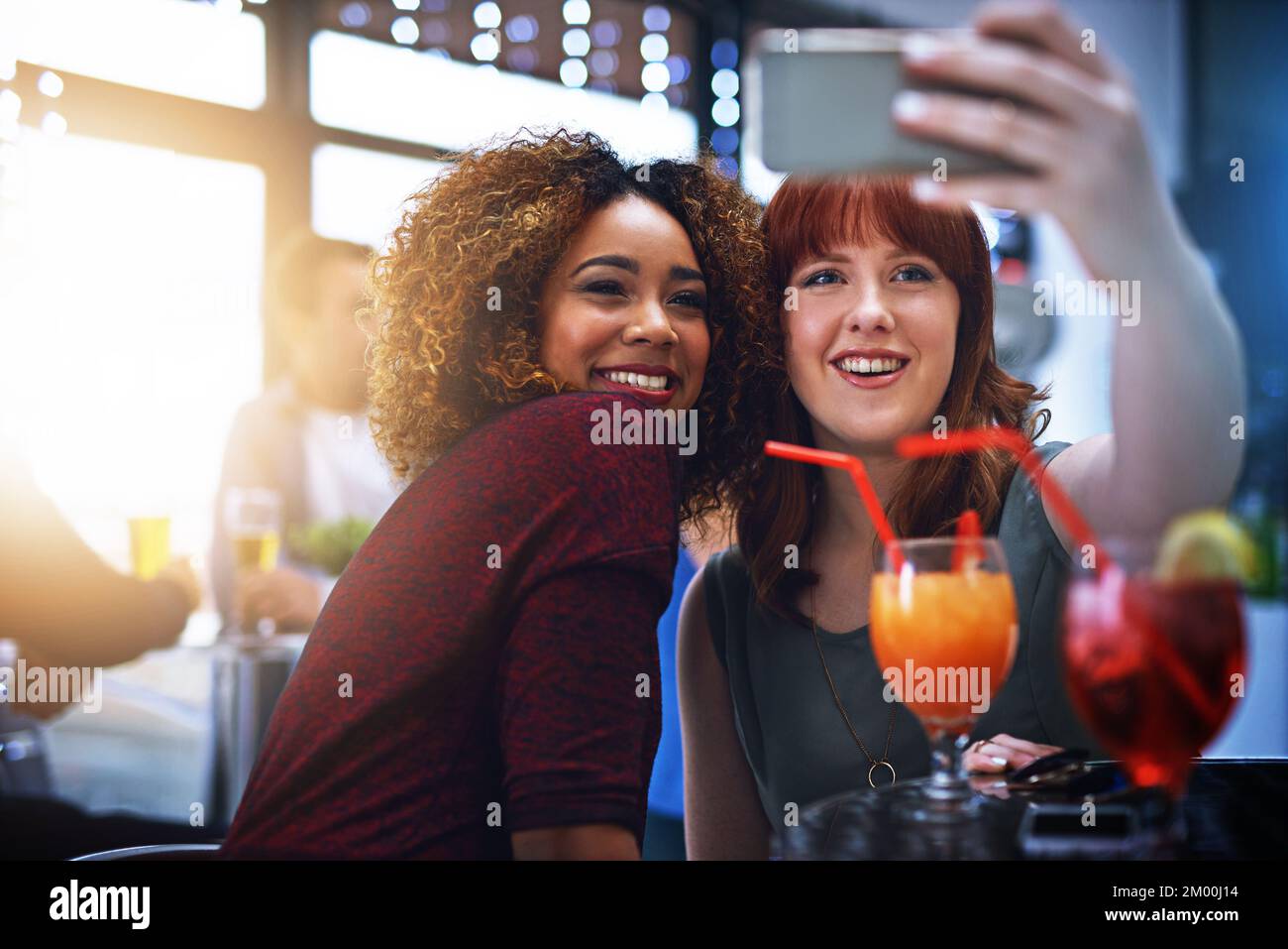 Friends, smartphone selfie and smile with drinks at party or year end ...