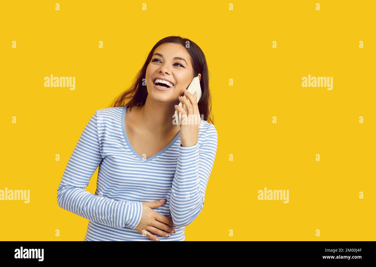 Portrait of excited woman touching her stomach with hand talking on ...