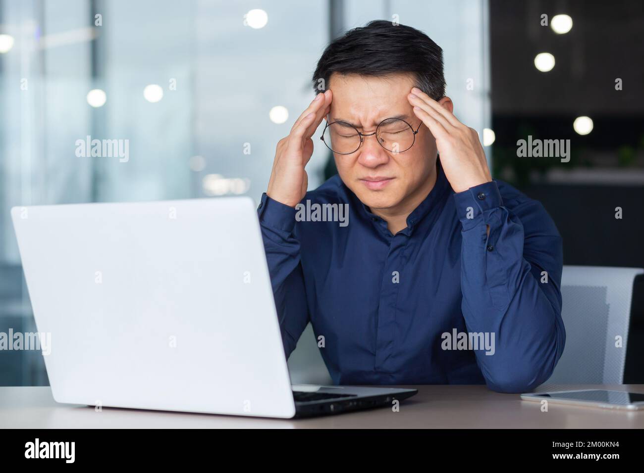 Asian businessman boss sick has severe headache, man in glasses sitting ...