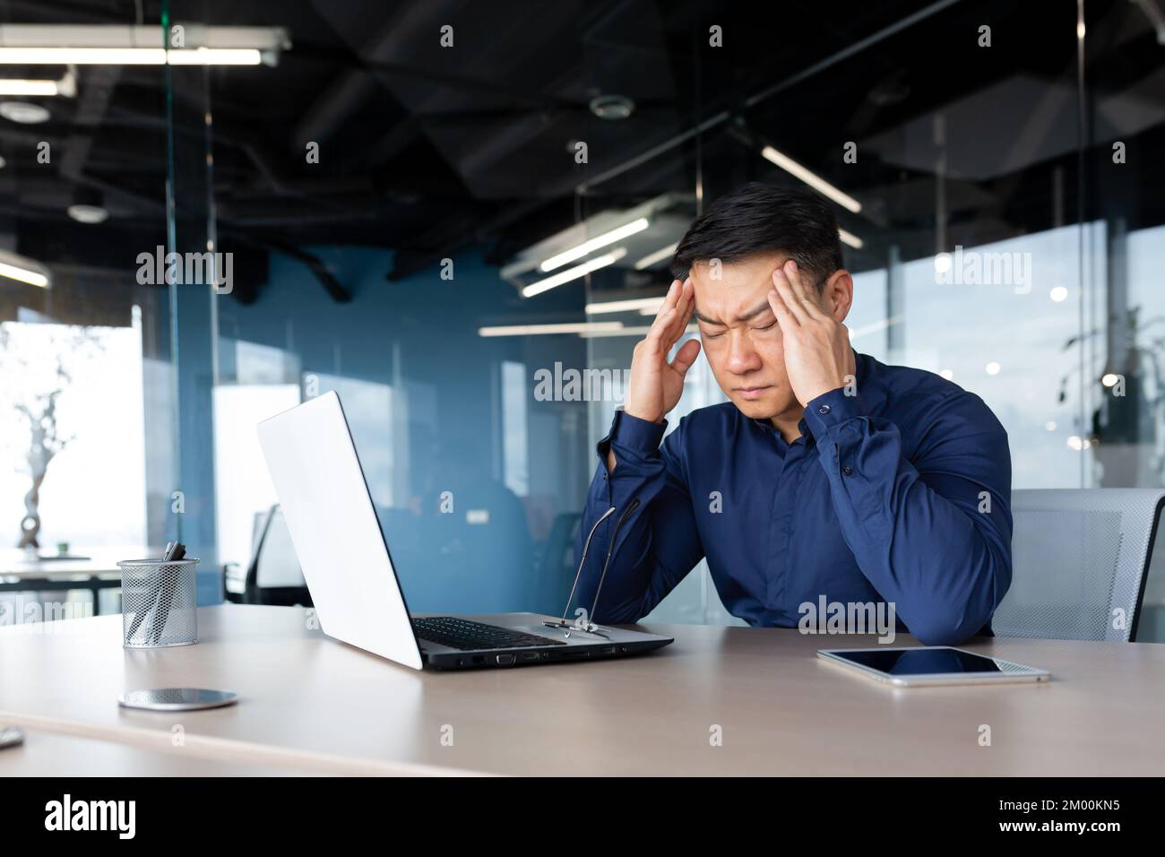 Asian businessman boss sick has severe headache, man in glasses sitting ...