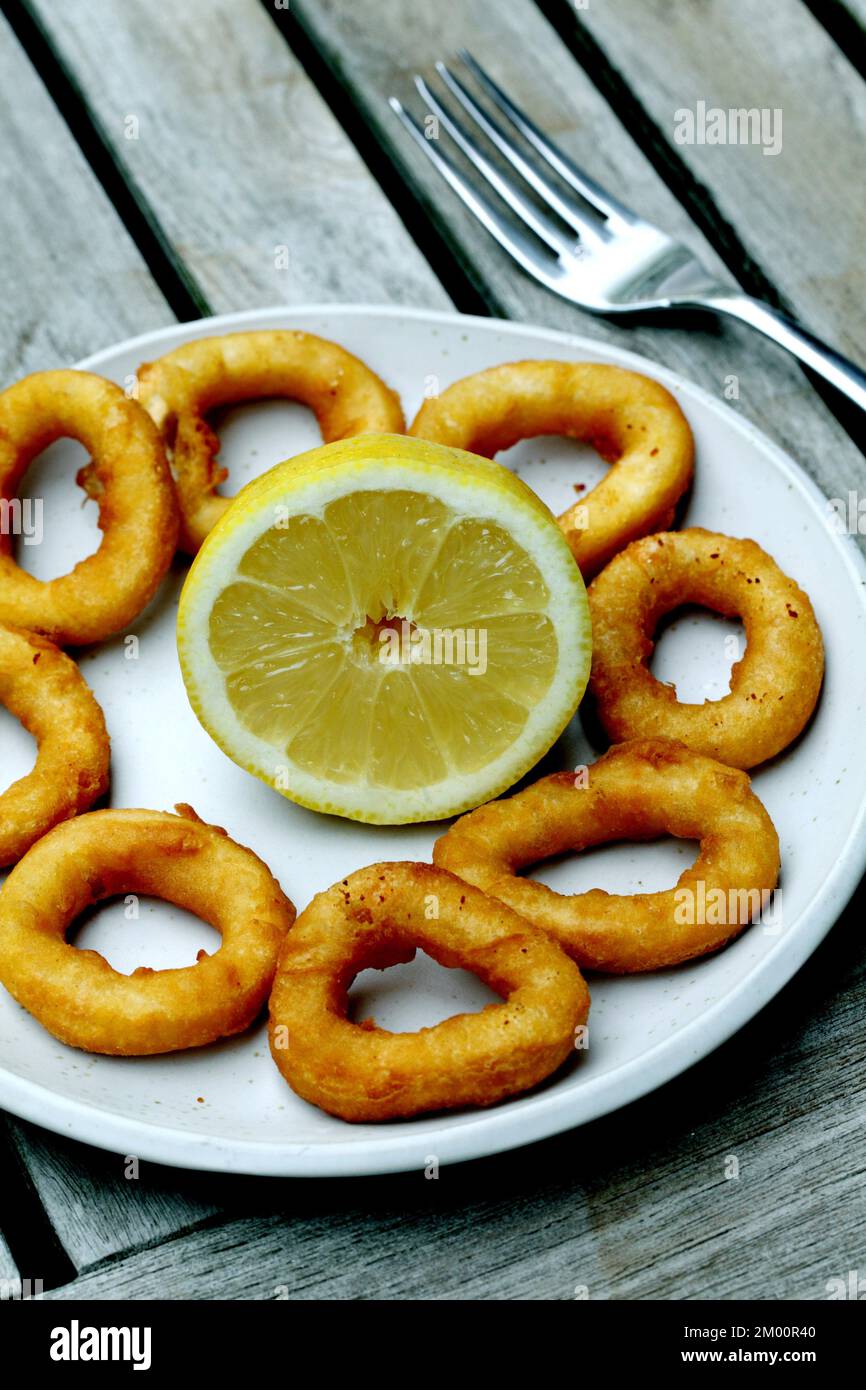 Fried calamari rings with lemon in white plate Stock Photo - Alamy