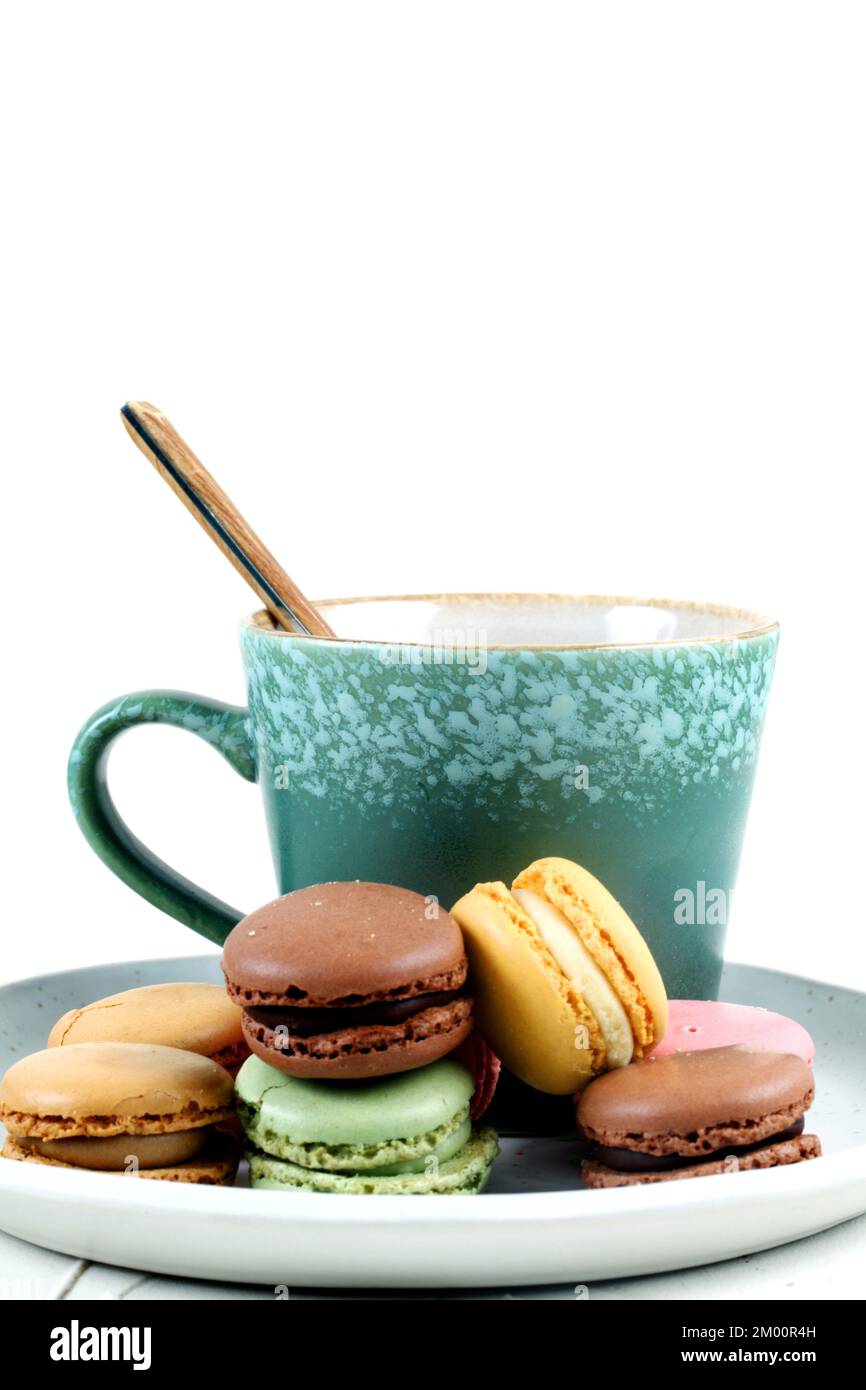 Colored macaroons on blue plate with white background Stock Photo - Alamy