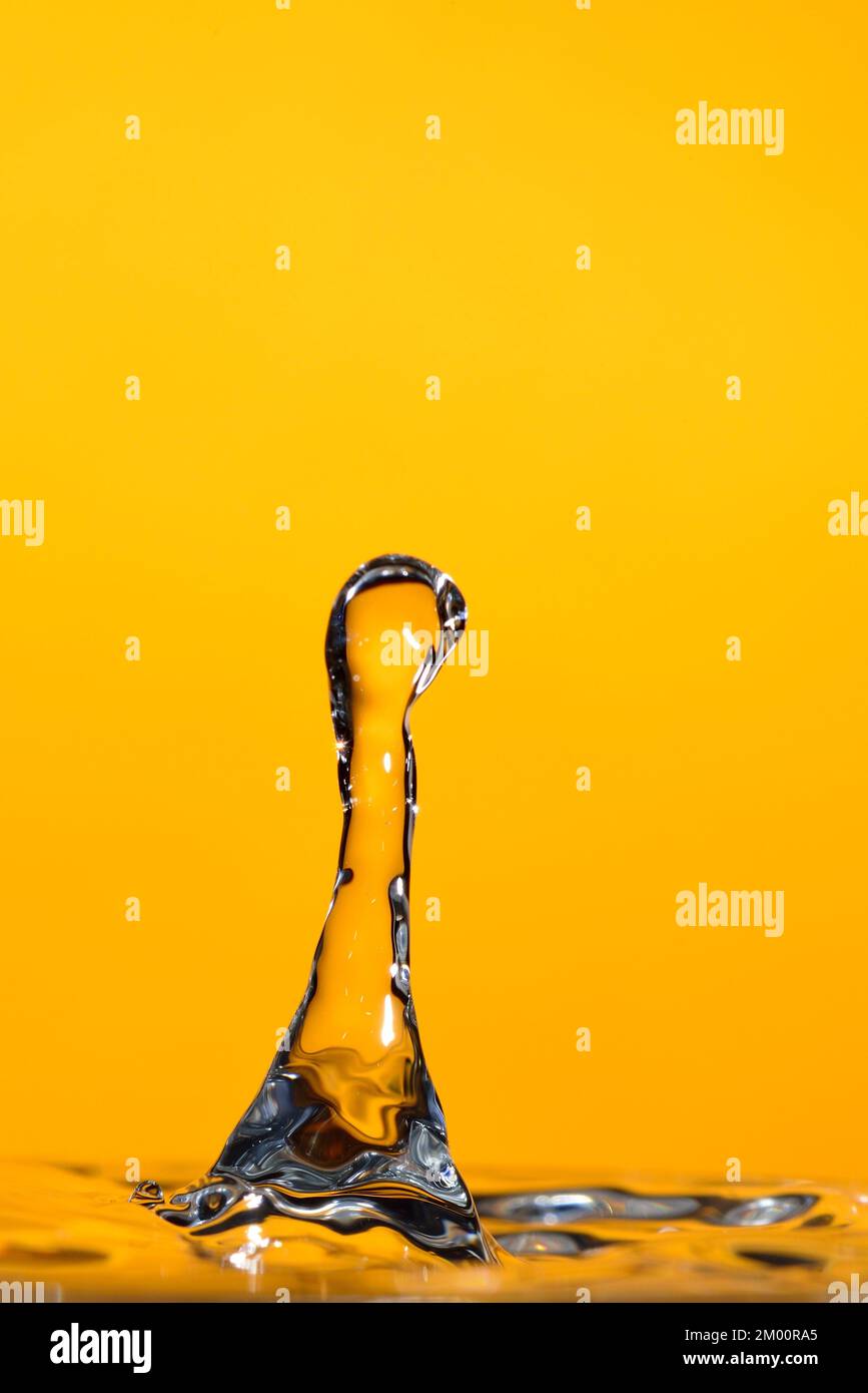 Falling drop waterdrop surface yellow hi-res stock photography and ...