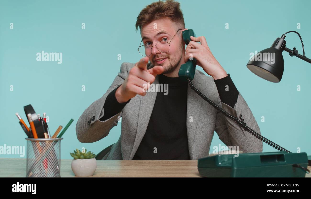 Hey you, call me back. Happy bearded business man sitting at office ...