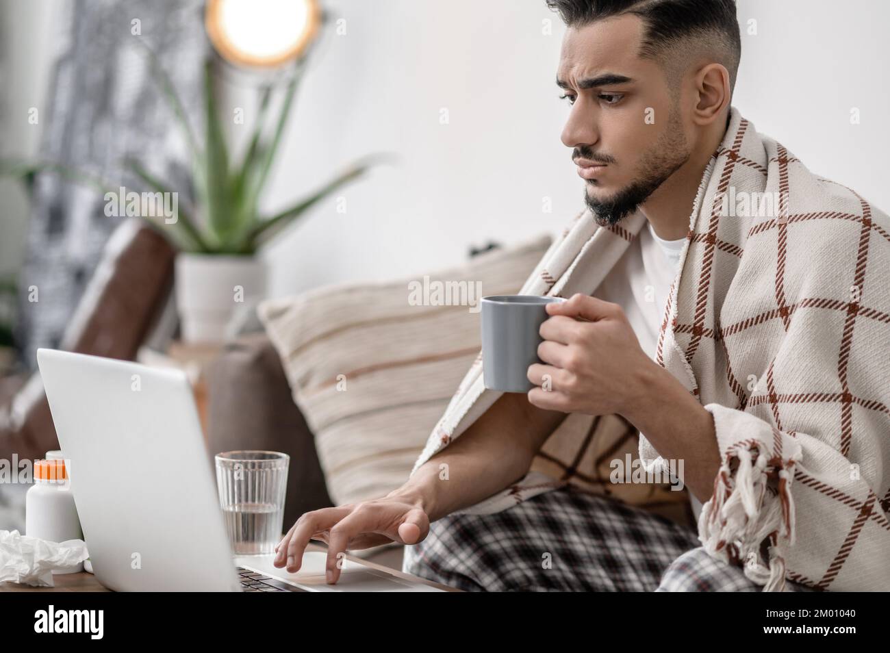 Telemedicine. A sick man sitting at the laptop and talking to the ...