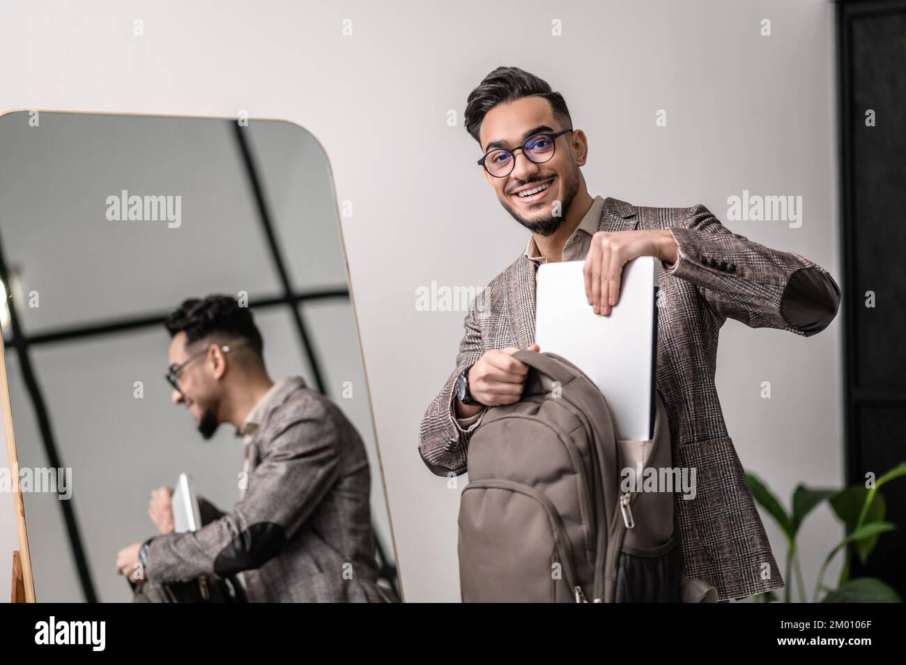 Packing a backpack. A stylish man apacking his backpack before leaving ...