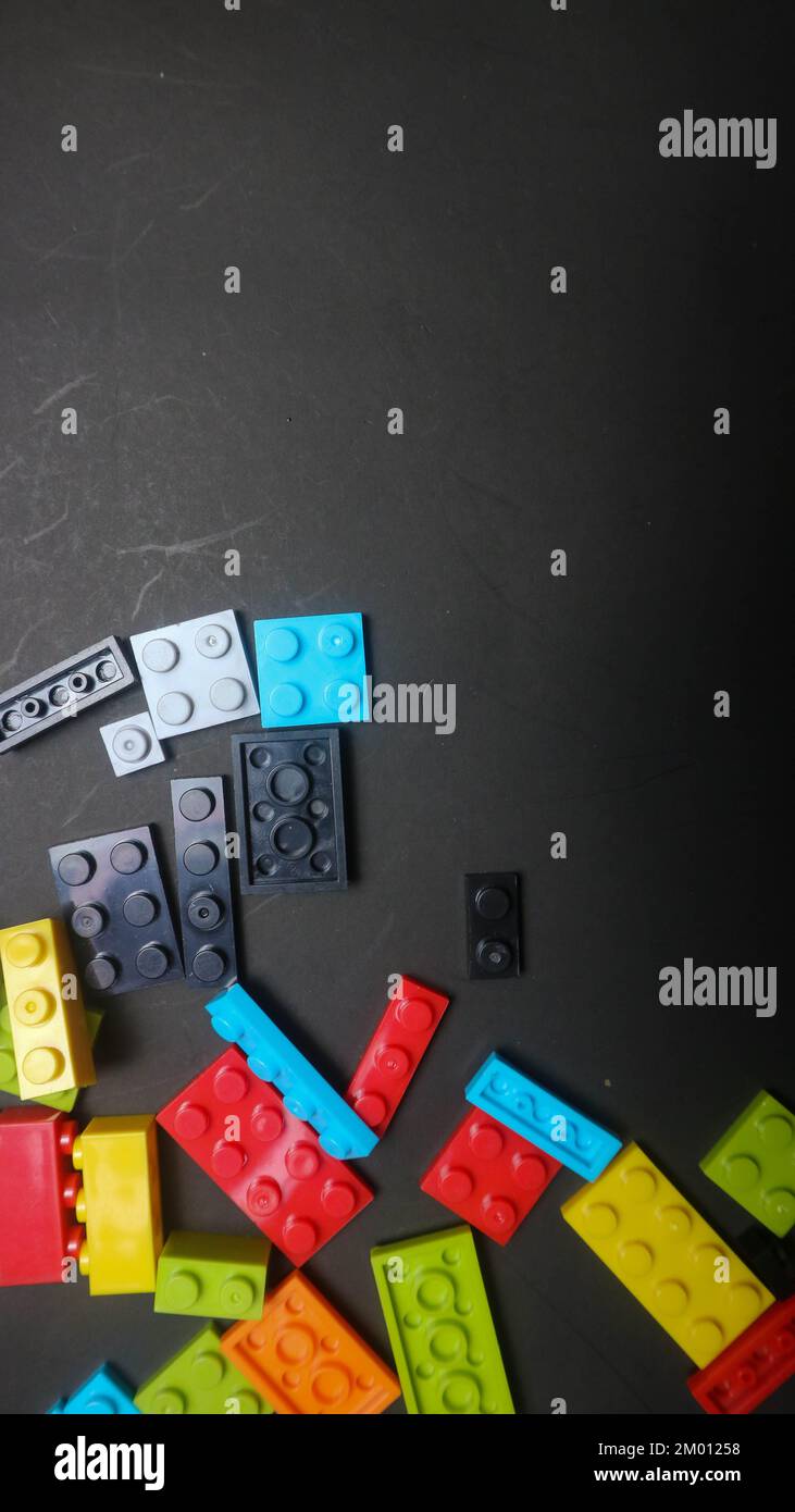 Plastic toy blocks on black background Stock Photo - Alamy