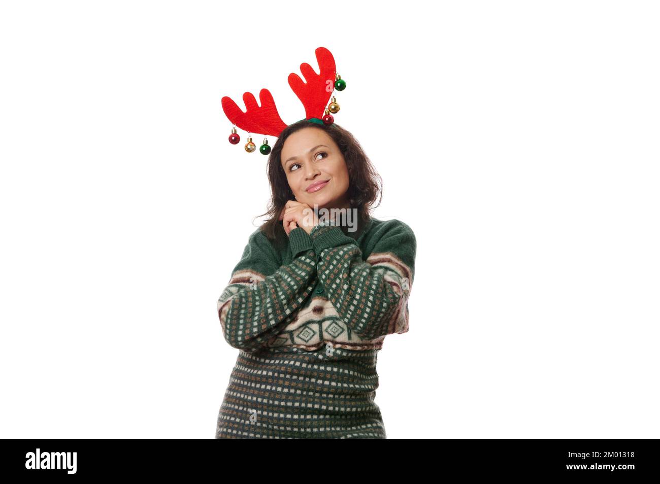 Charming woman in green sweater and deer antler hoop, smiling, dreamily ...