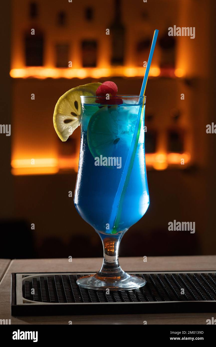Closeup glass of Blue Lagoon Cocktail decorated with lime at bar ...