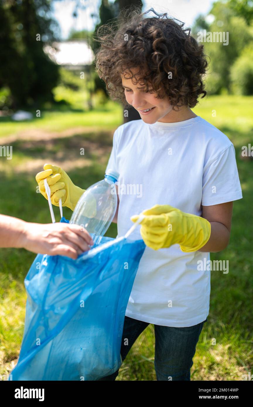Garbage. Someone helping a curly-haired teen to gather garbage Stock ...