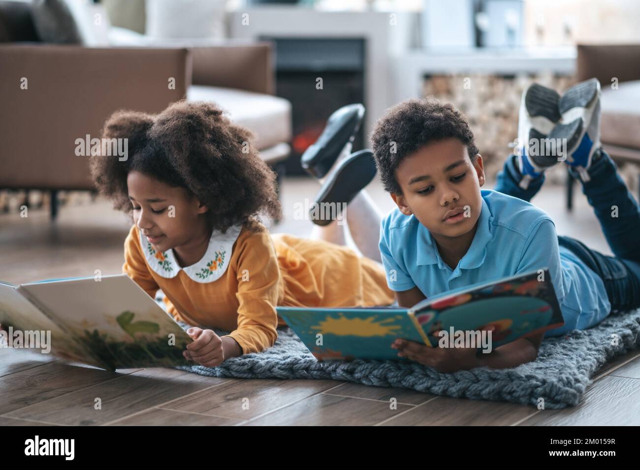 Kid lying on floor reading hi-res stock photography and images - Alamy
