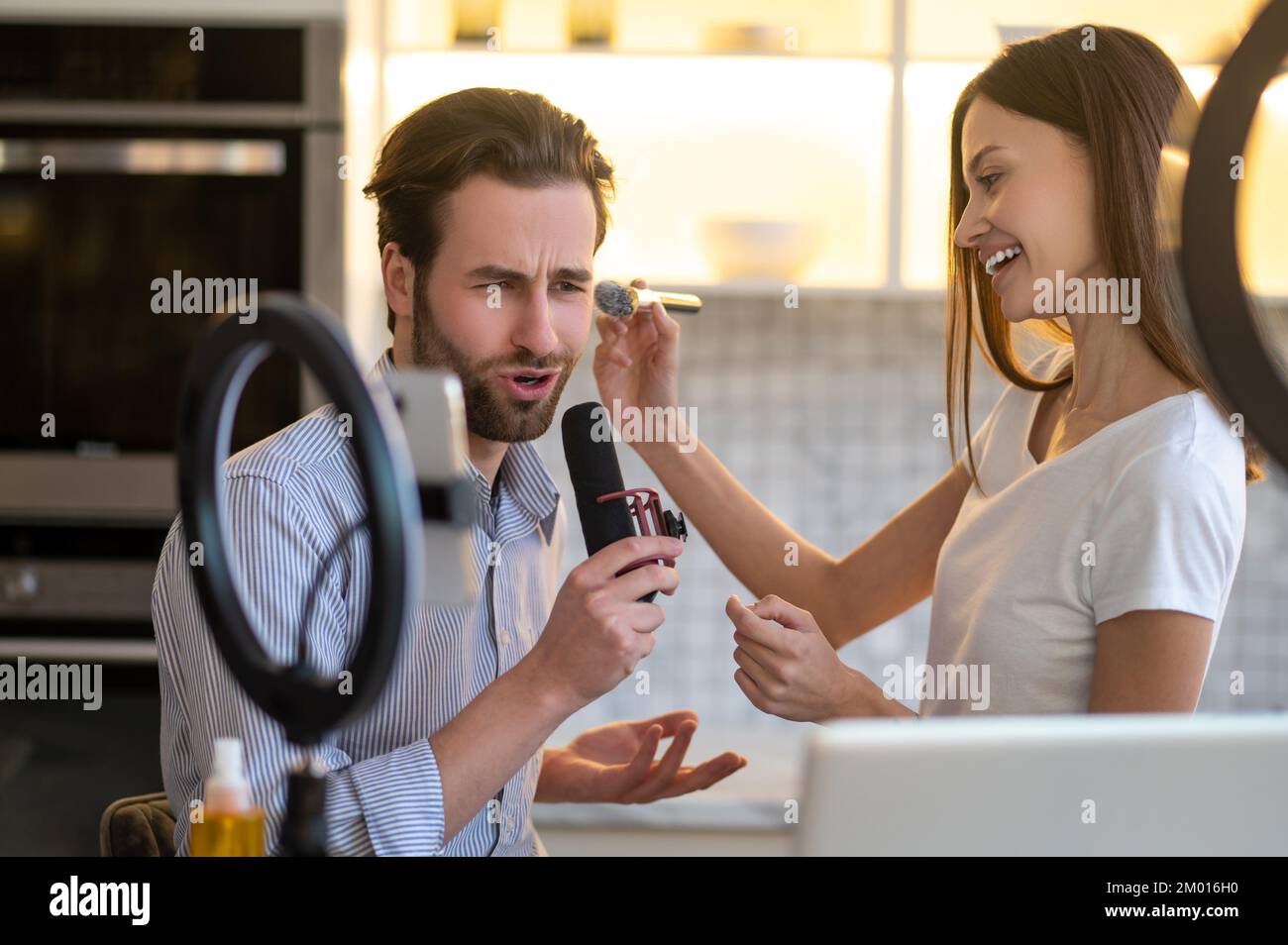 Preparation. Female stylist doing make up to a journalist before ...