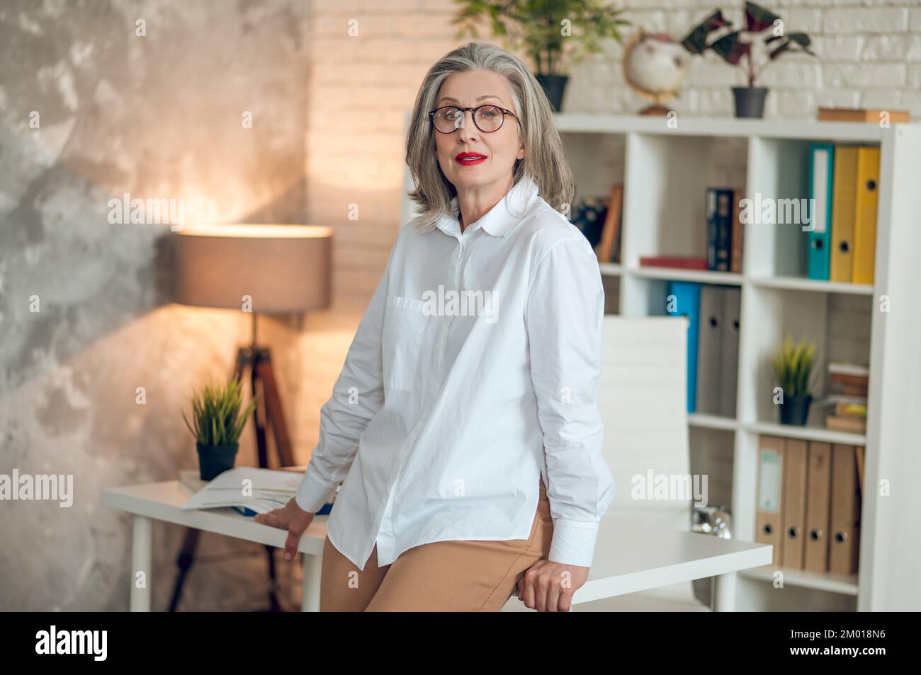 Business woman. Good-looking woman standing in the office near the ...