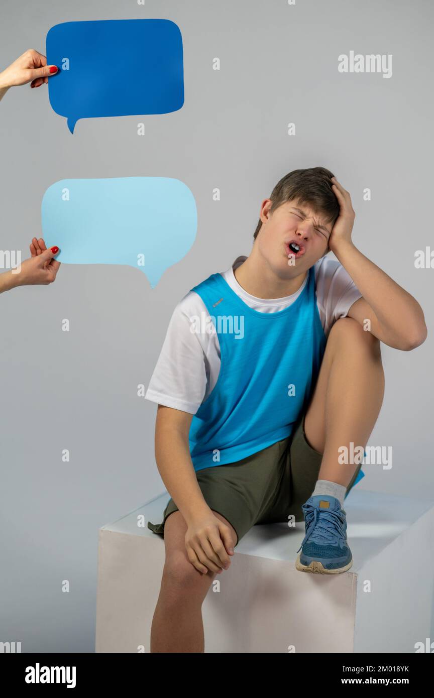 Bored. A boy in a blue thsirt sitting with a bored look Stock Photo - Alamy