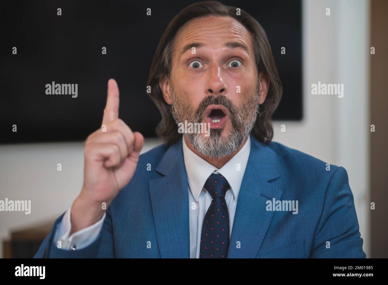 Surprising news. Bearded businessman in a suit looking surprised Stock ...