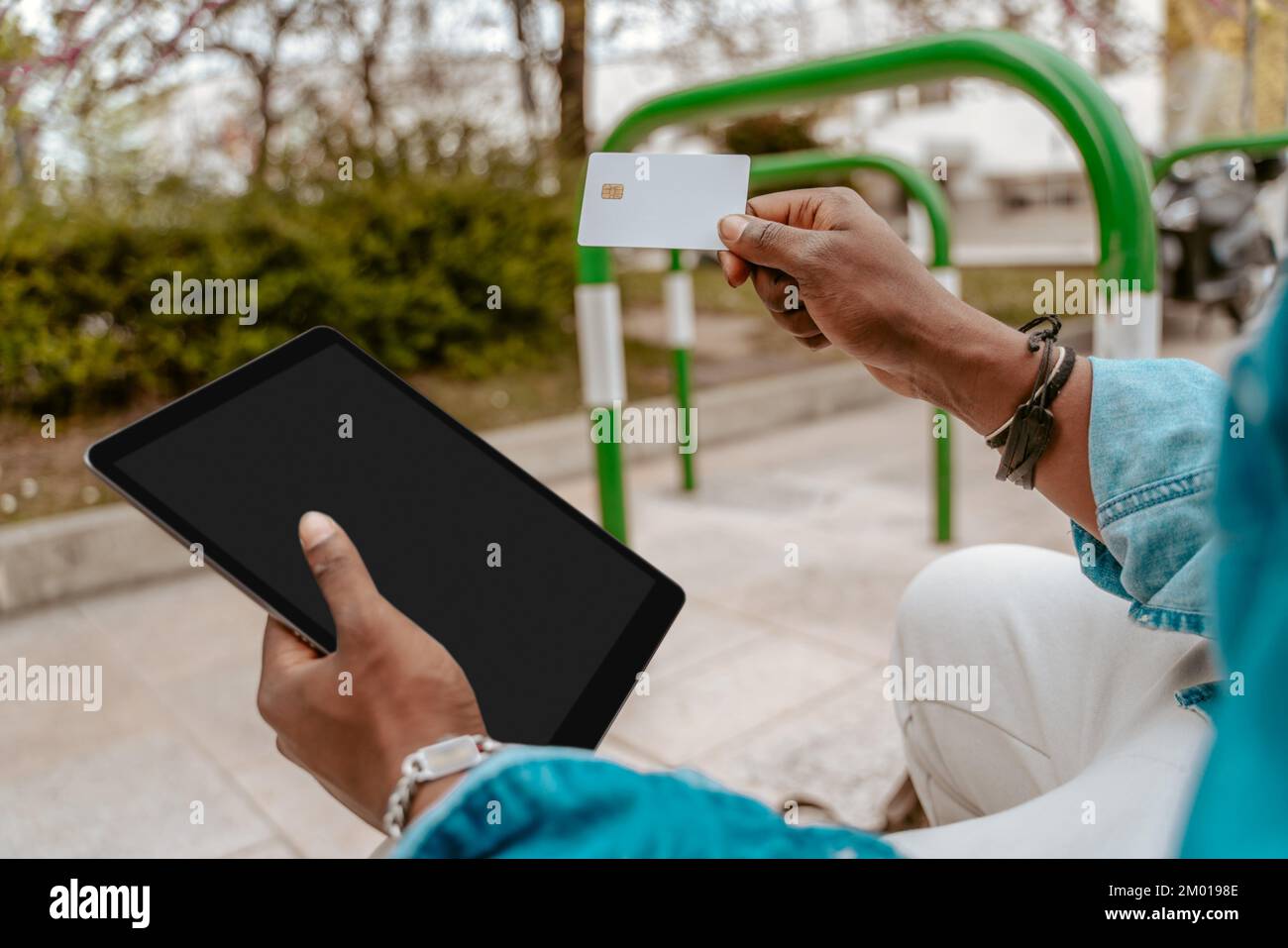 Ease of use. Hands of dark skinned man sitting on street holding card ...