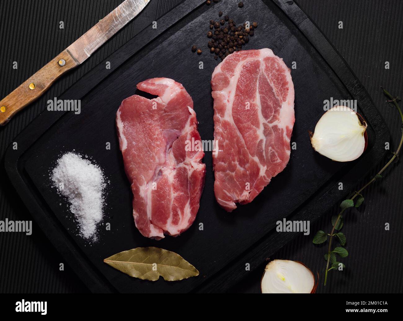 Food concept Organic Fresh pork chop on black slate stone board with ...