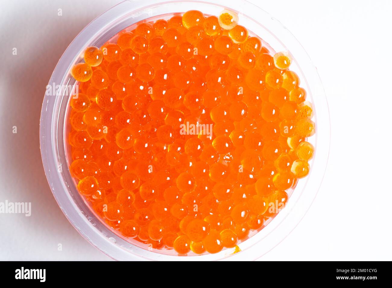 Yellow caviar in a jar, on a white background close-up Stock Photo - Alamy