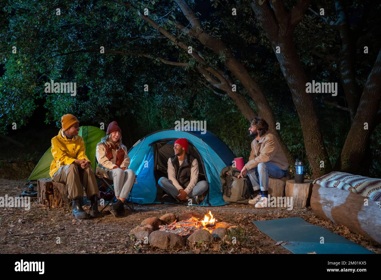 Group of multiethnic friends happy around the bonfire camping hike ...