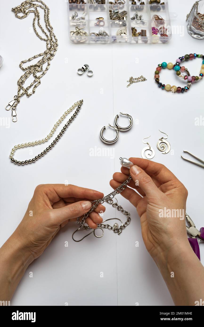 The designer makes handmade jewelry at the workplace Stock Photo - Alamy