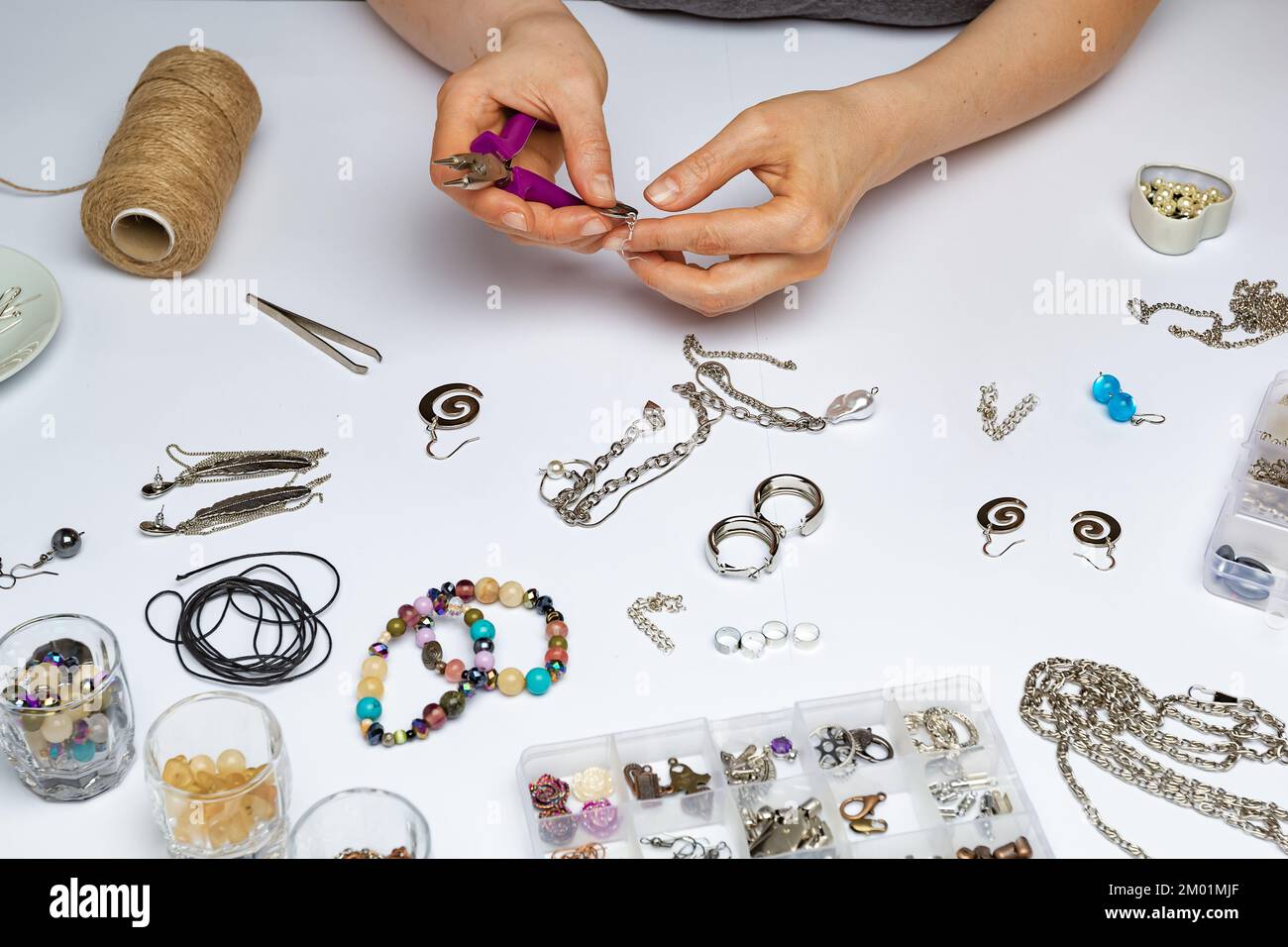 The designer makes handmade jewelry at the workplace Stock Photo - Alamy