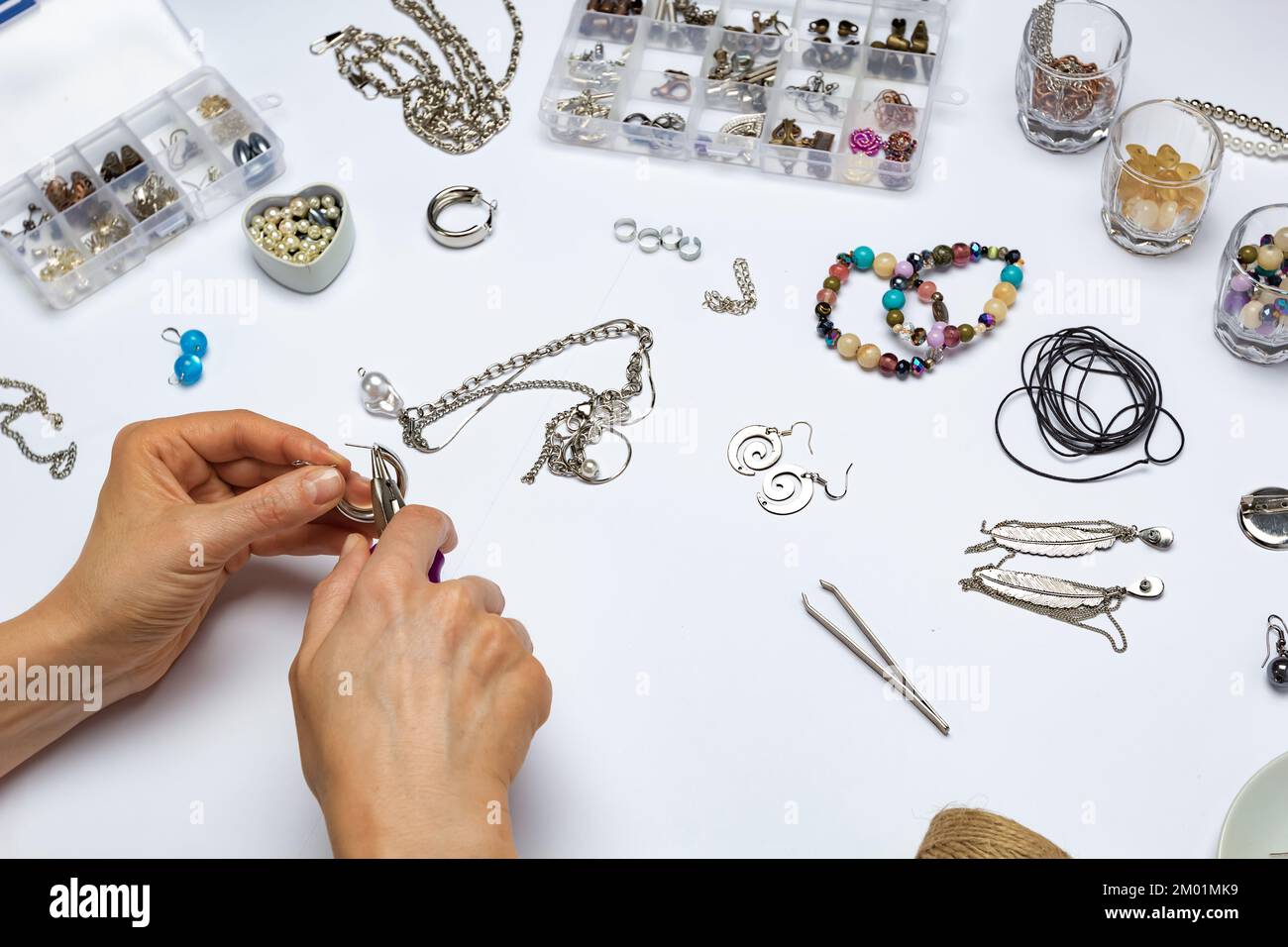 The designer makes handmade jewelry at the workplace Stock Photo - Alamy