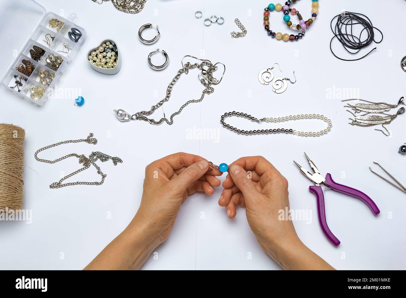 The designer makes handmade jewelry at the workplace Stock Photo - Alamy