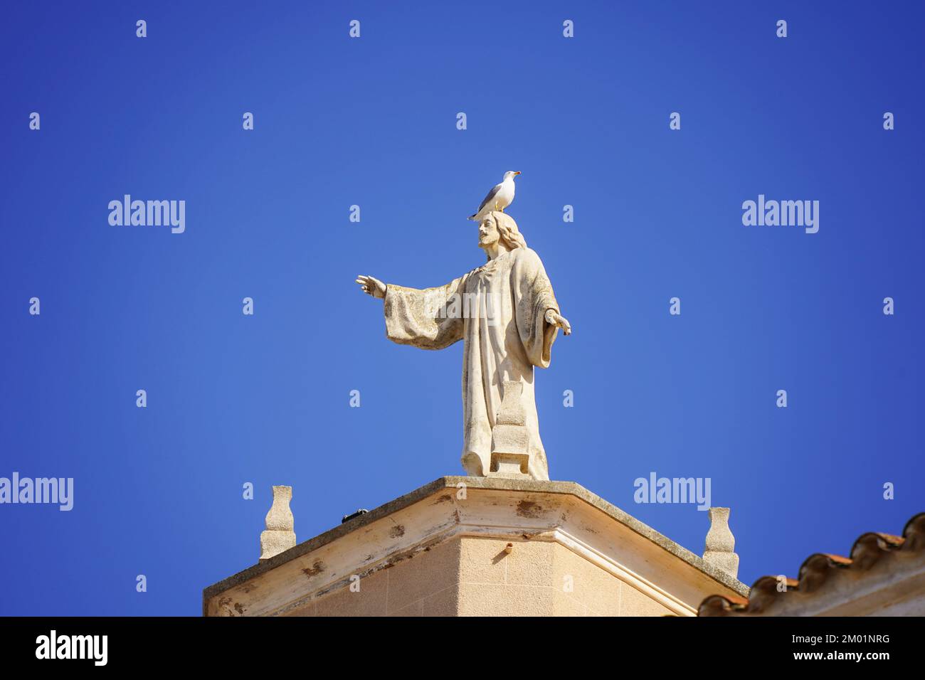 Jesus Christ statue, with a Seagull on its head, located on the rooftop ...