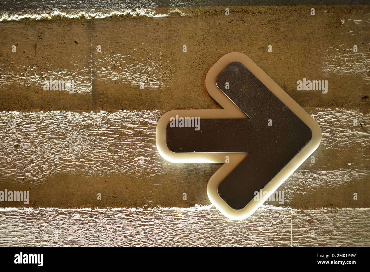 close up shot of brown arrow on concrete wall at night Stock Photo - Alamy
