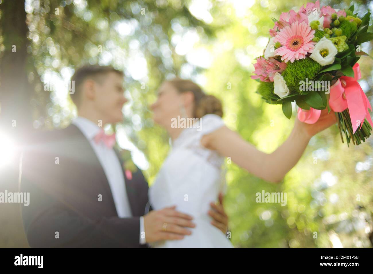 Wedding shot of bride and groom stand in park (focus on bouquet Stock ...