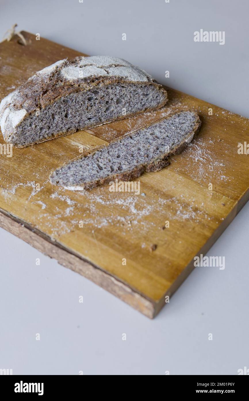 Dark rye bread on wooden cutting board breakfast table Stock Photo - Alamy
