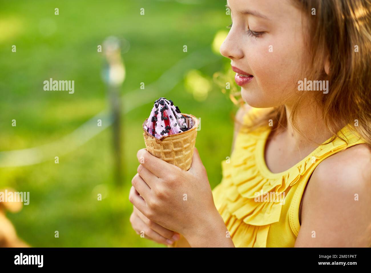 Happy girl with braces eating italian ice cream cone smiling while ...