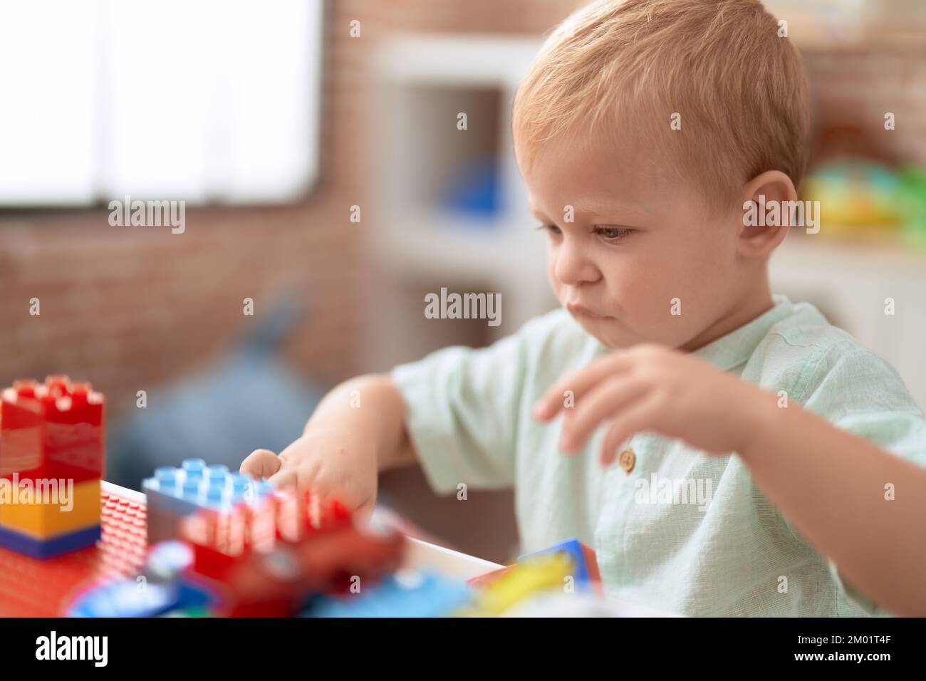 Adorable toddler playing with construction blocks standing at ...