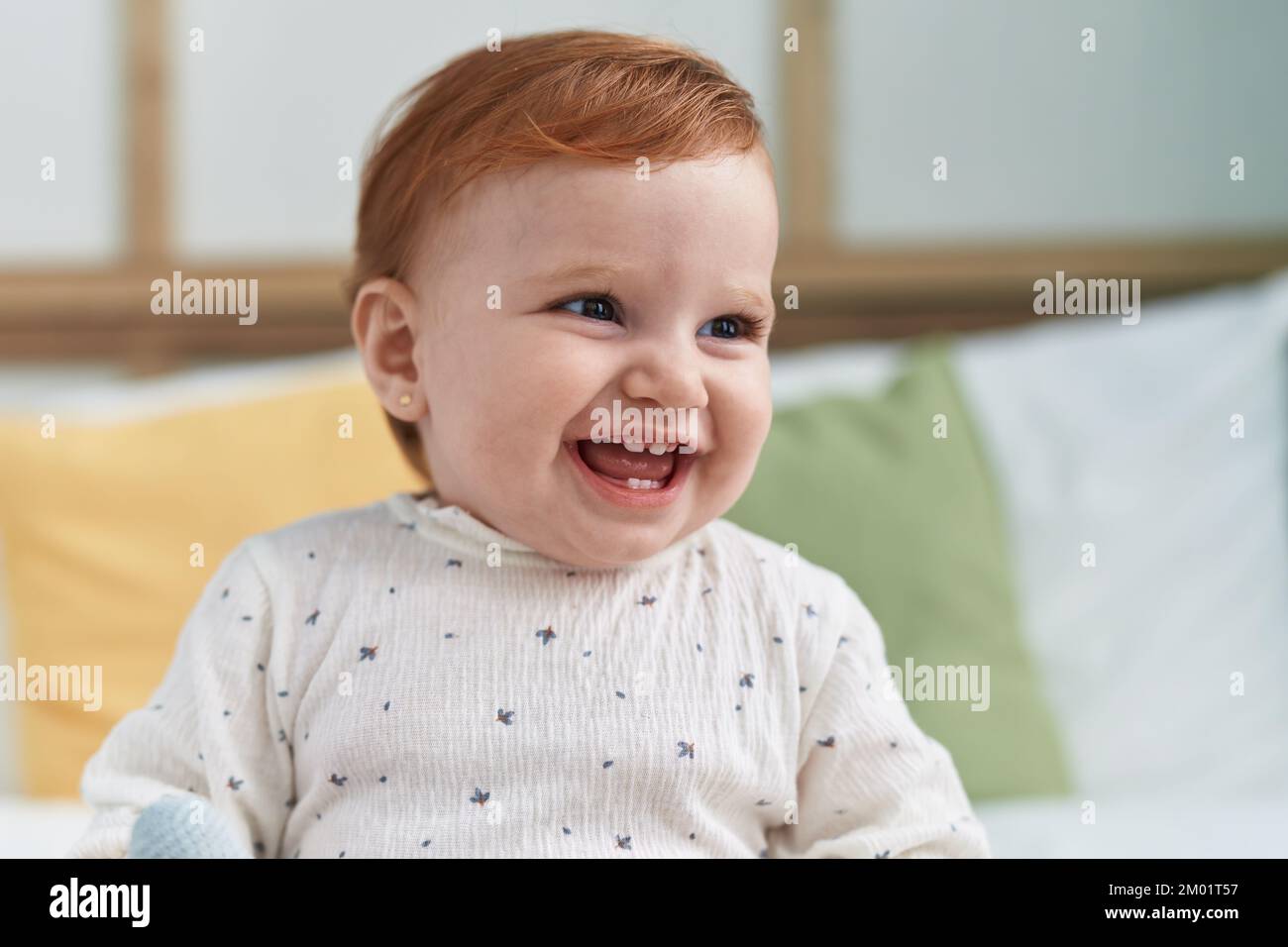 Adorable redhead toddler smiling confident sitting on bed at bedroom ...