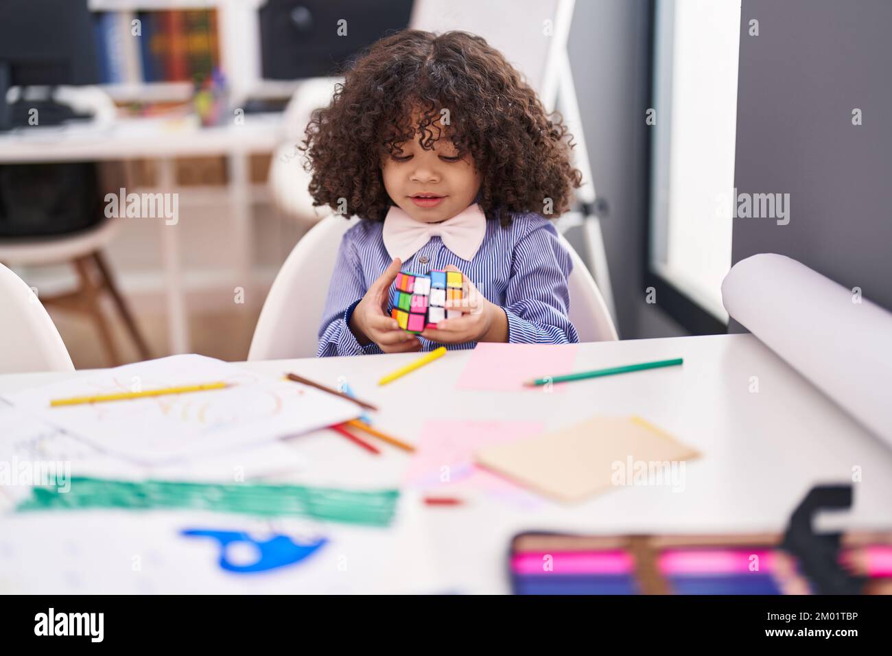African american toddler preschool student sitting on table solving ...