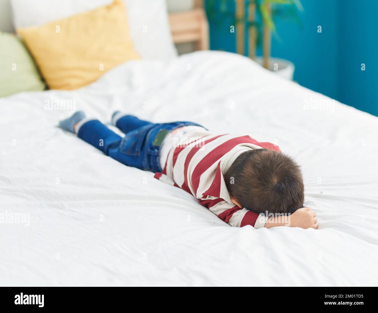 Adorable toddler lying on bed crying at bedroom Stock Photo - Alamy