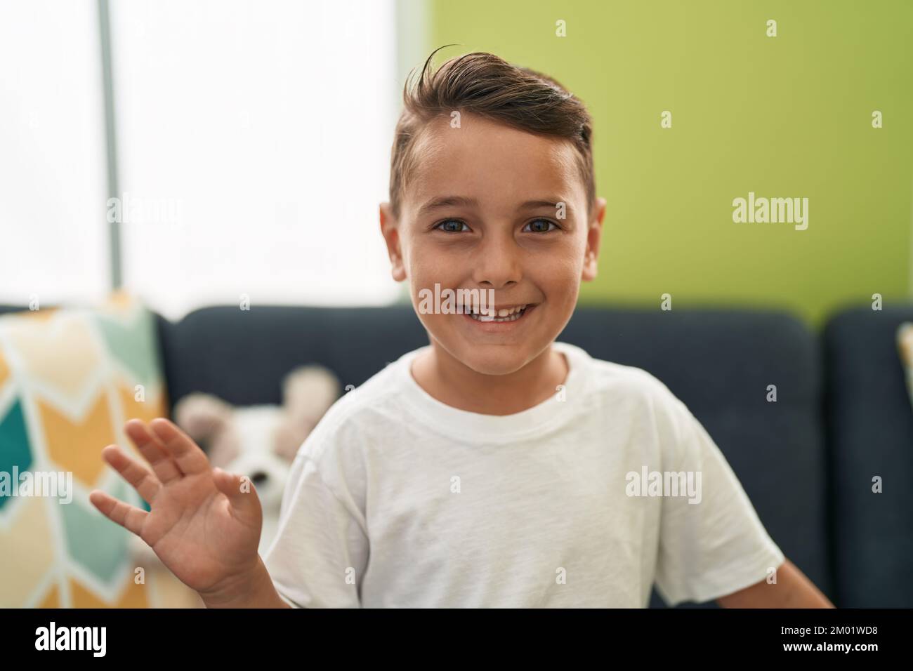 Adorable hispanic toddler smiling confident saying hello with hand at ...