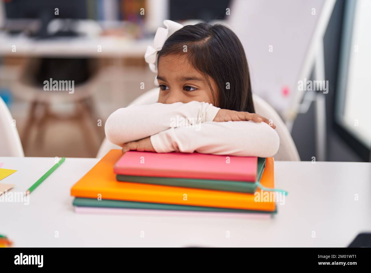 Adorable hispanic girl student smiling confident leaning on book at ...