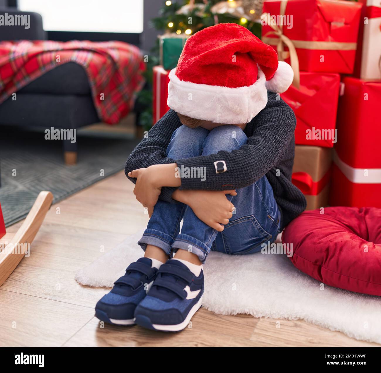 Adorable toddler sitting on floor by christmas tree crying at home ...