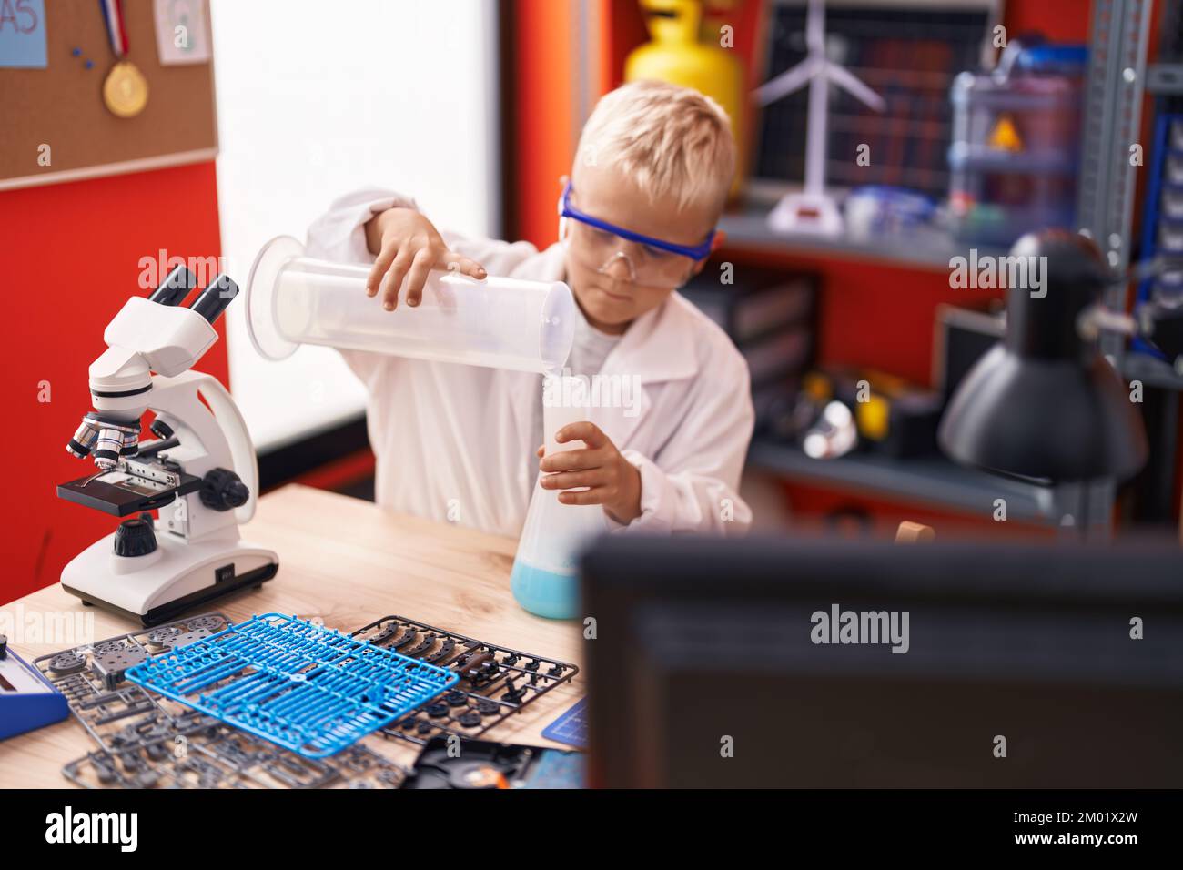 Adorable toddler student pouring liquid on test tube at classroom Stock ...