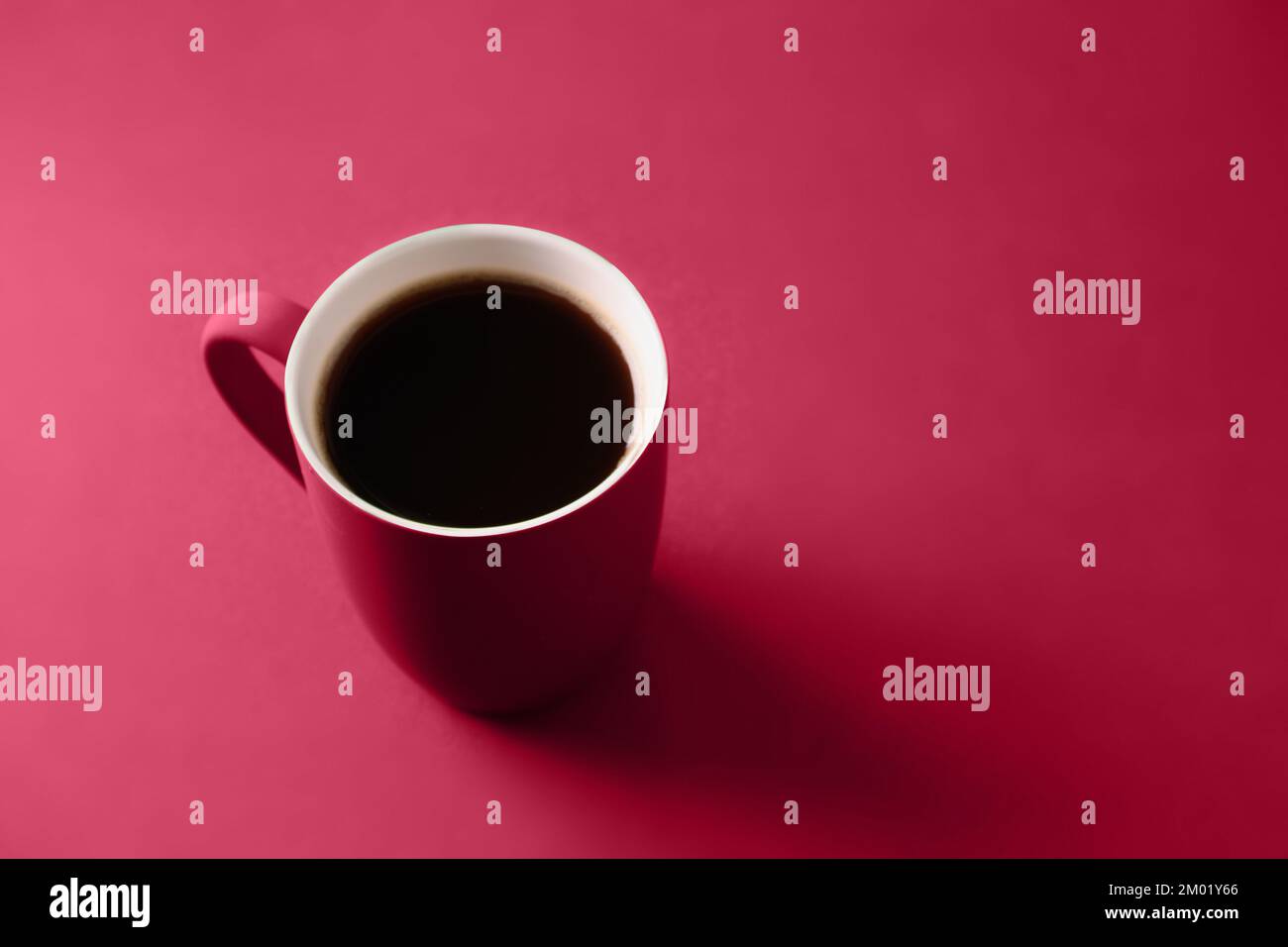 Coffee in viva magenta cup on monochrome background. Close up. Copy ...