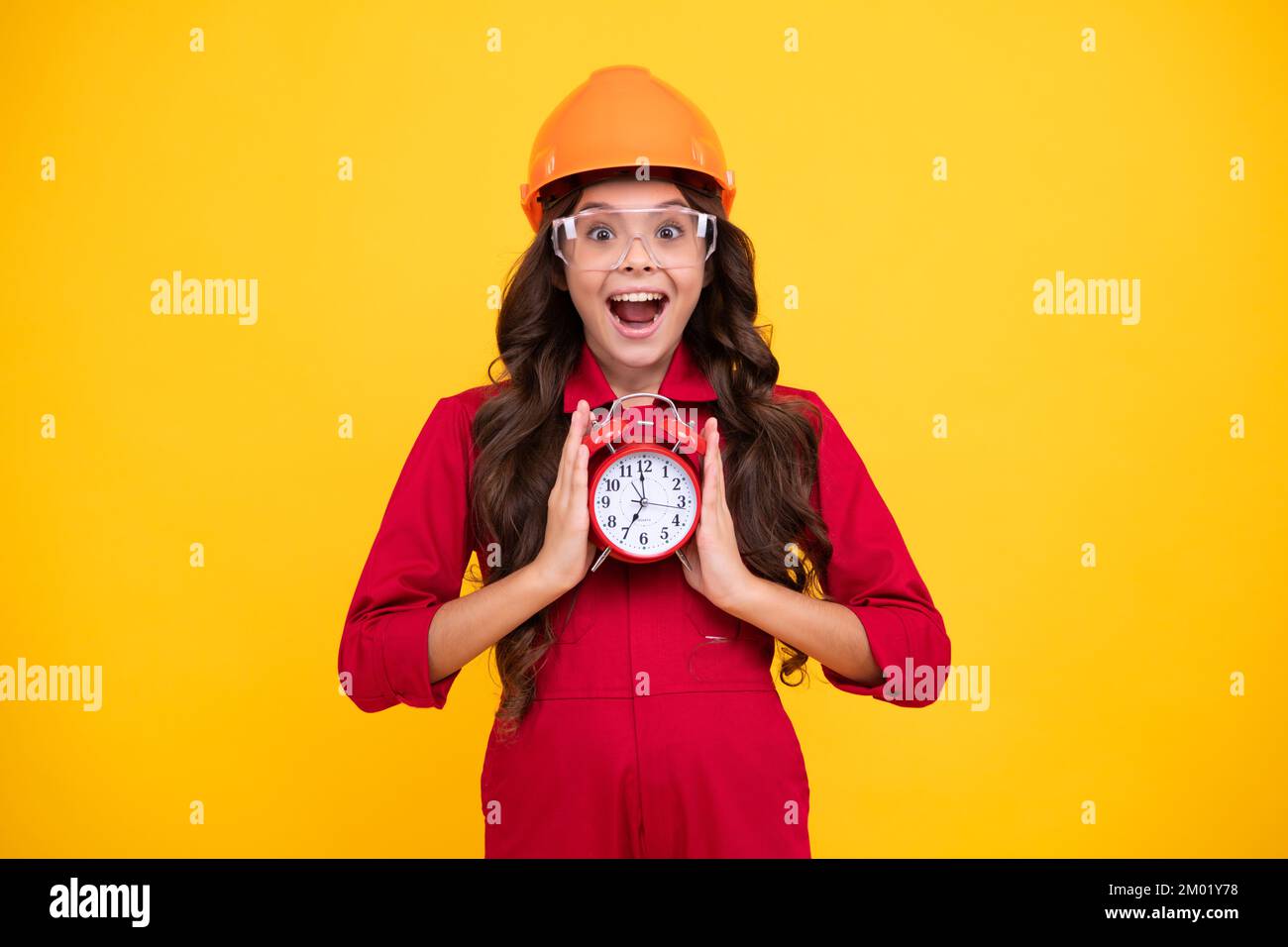 Excited teenager girl in builder helmet and clock alarm. Time to ...