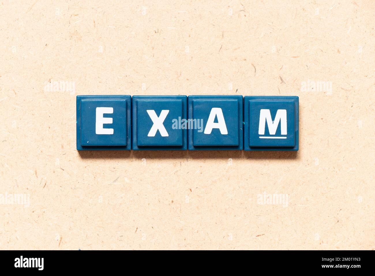 Tile letter in english word exam on wood background Stock Photo - Alamy