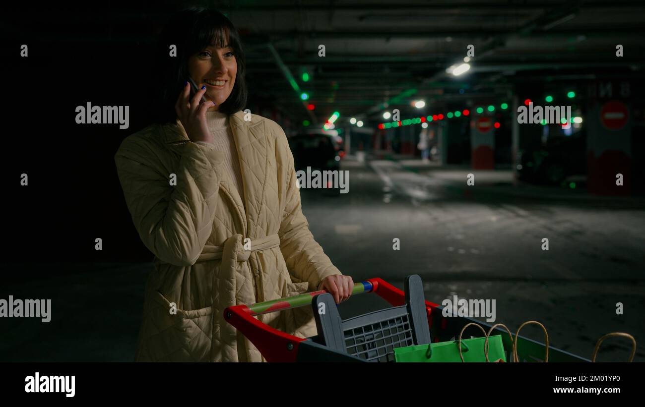 Smiling woman girl at mall parking lot answer call talking speaking ...