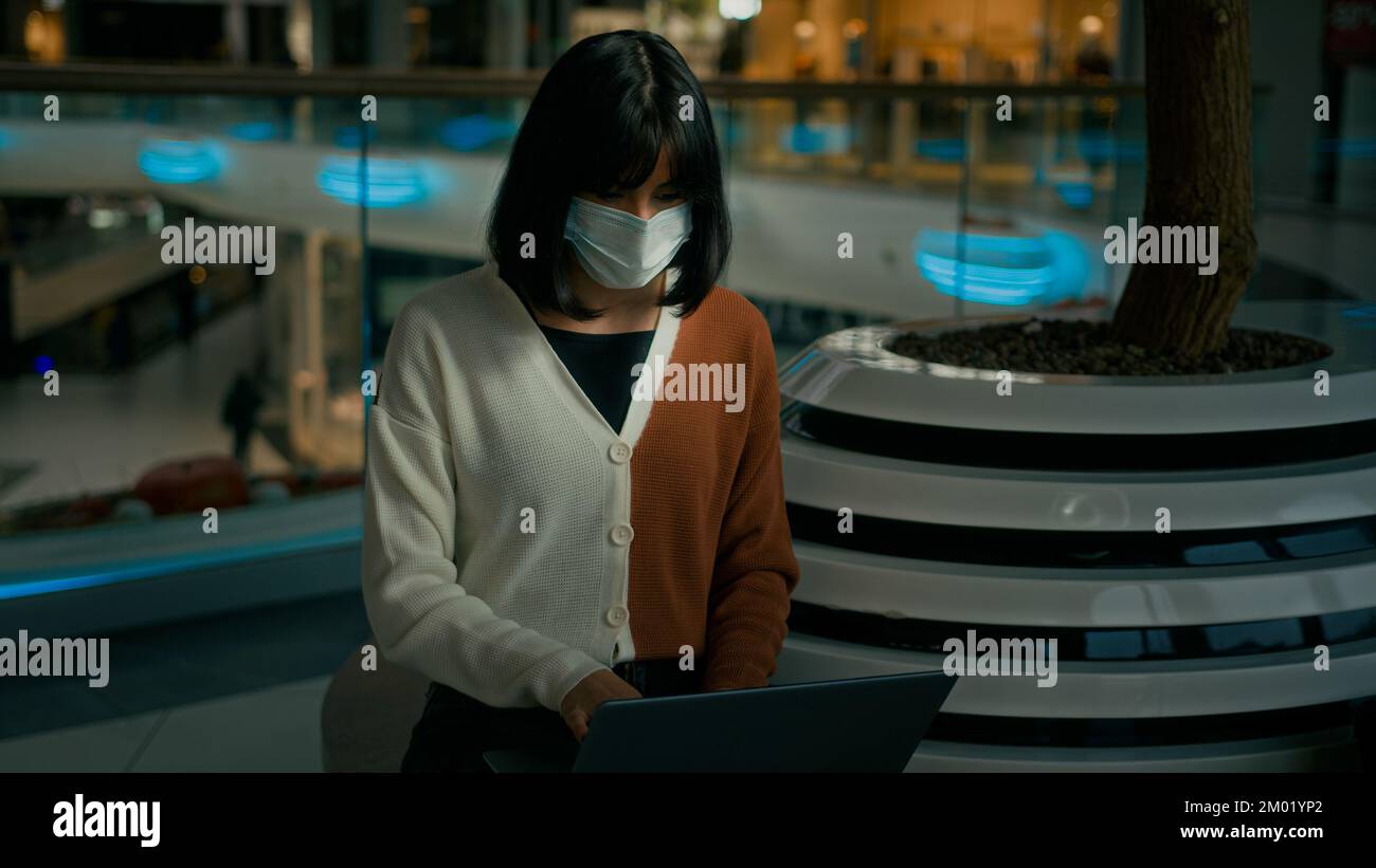 Covid-19 business. Woman in face medical mask working with computer in ...