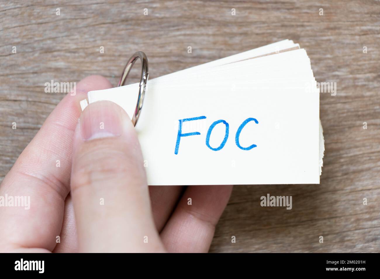 Hand hold flash card with handwriting in word FOC (Abbreviation of Free ...