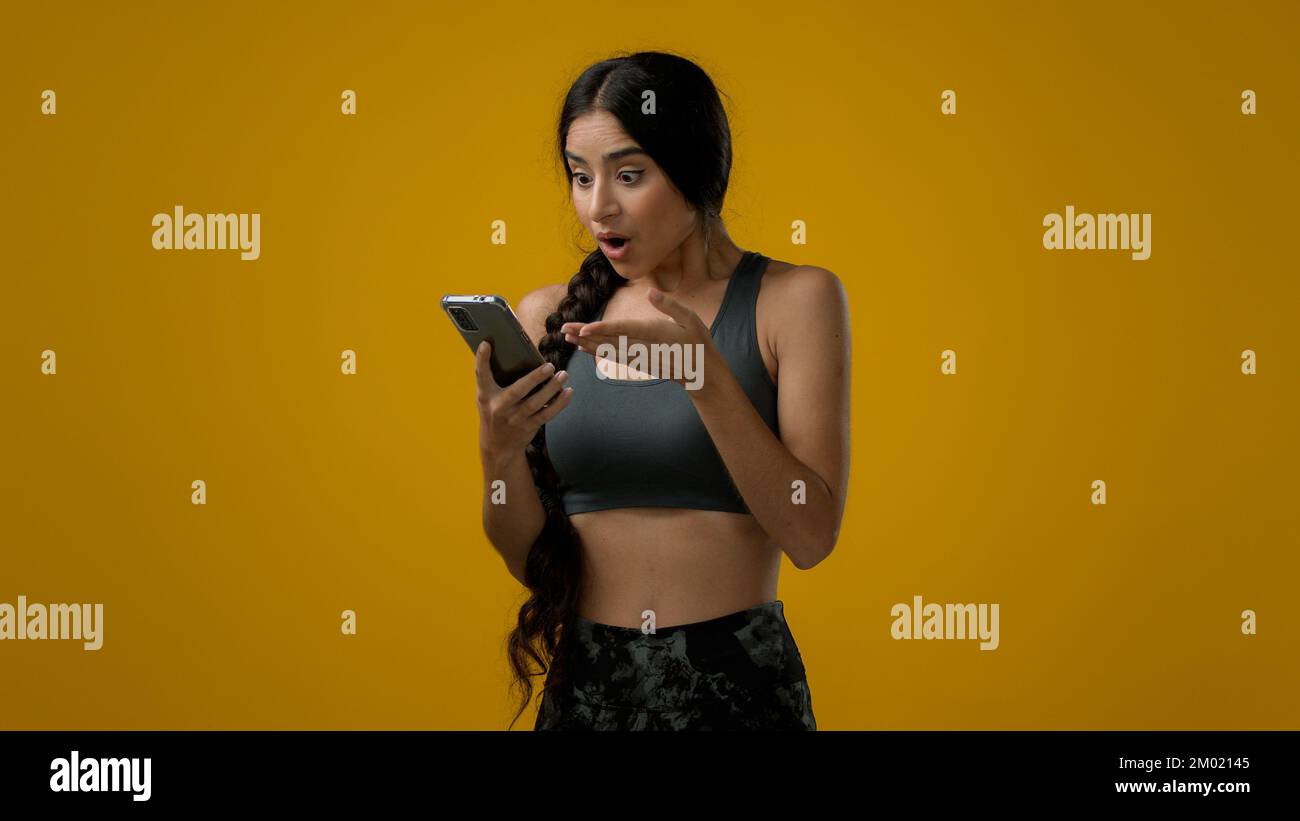 Shocked happy win Indian ethnic successful woman 20s lady sporty ...