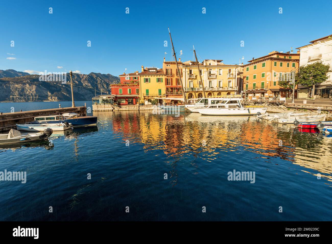 Malcesine village. Port with small boats and ferries moored and ...