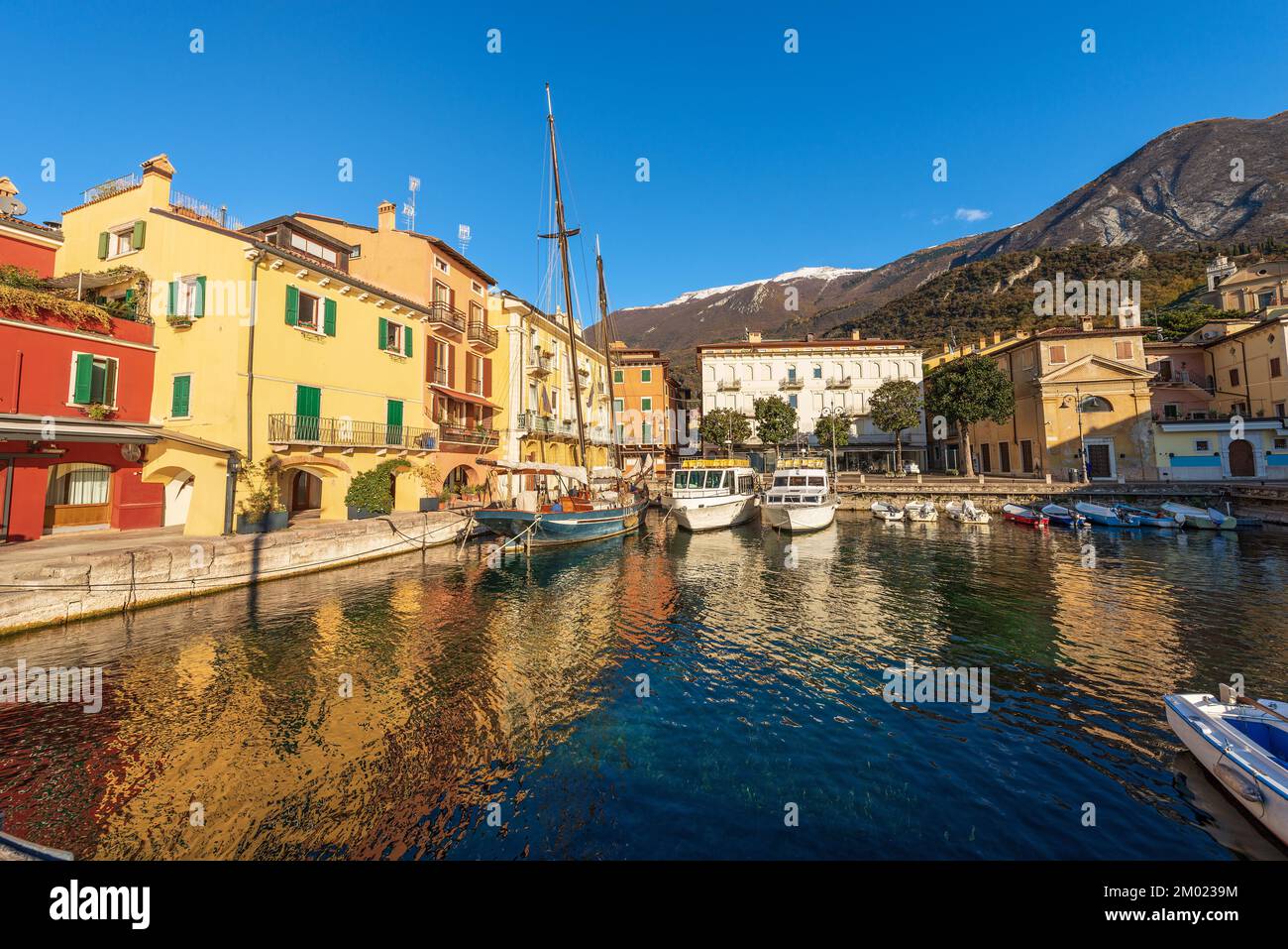 Malcesine village. Port with small boats and ferries moored and ...